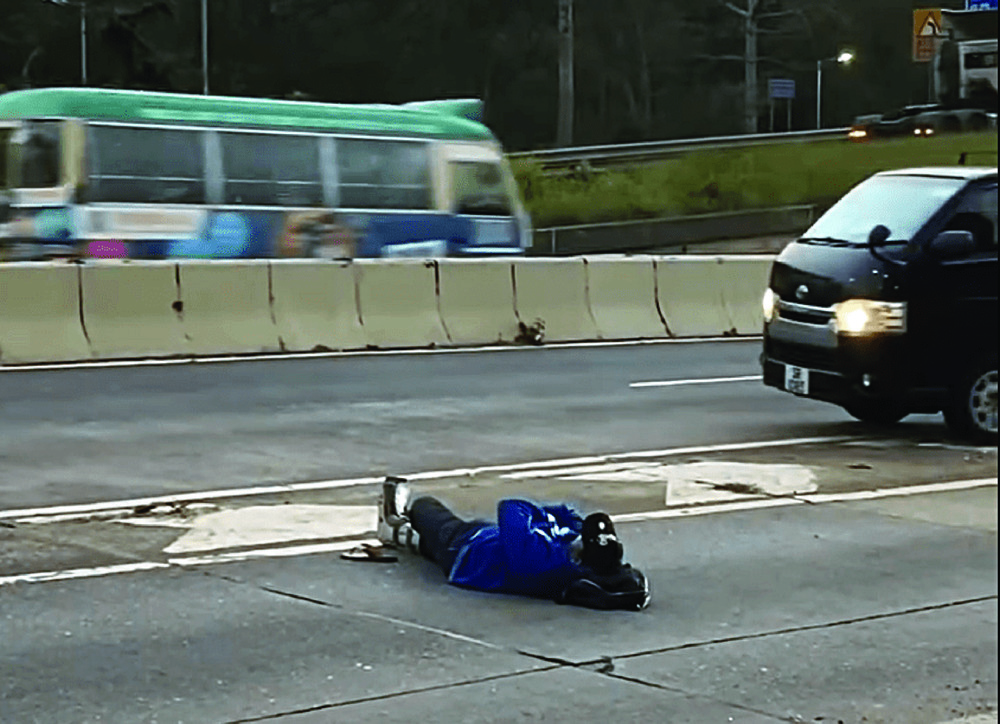 Man creates road hazard lying in road